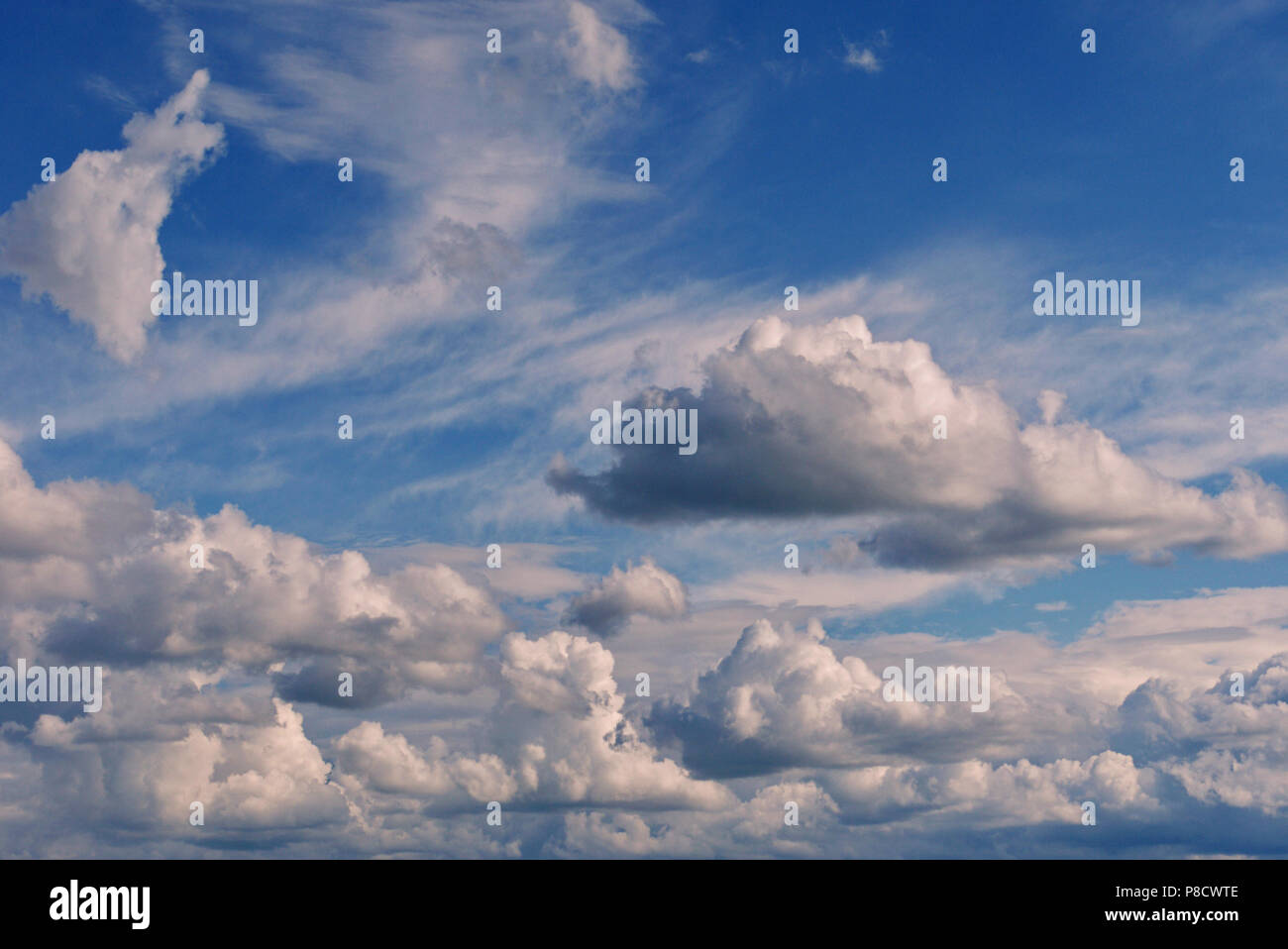 A pile of white dense clouds above each other in a low-lying blue sky ...
