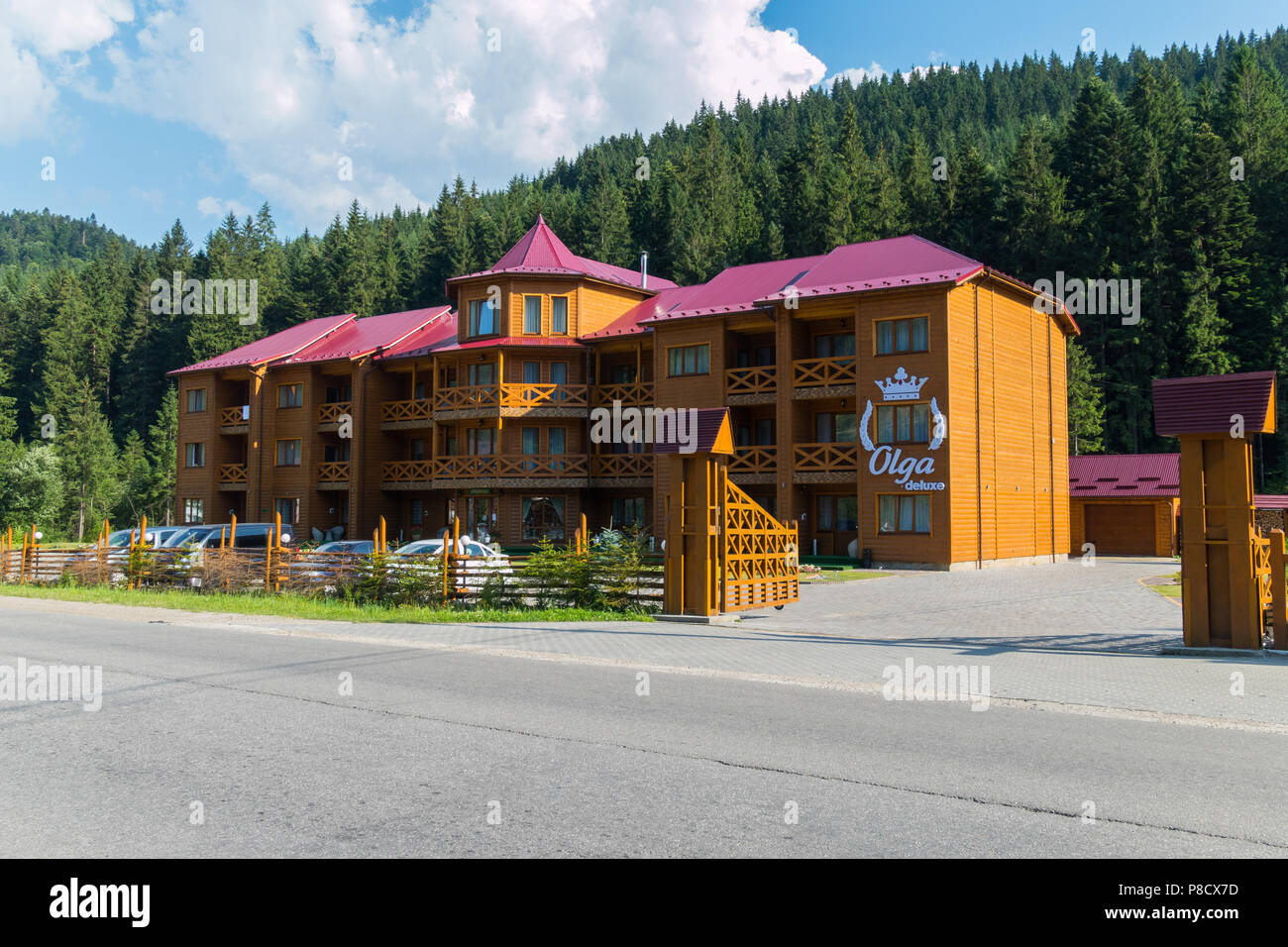 Three-storey hotel complex from a wooden frame on a background of green ...