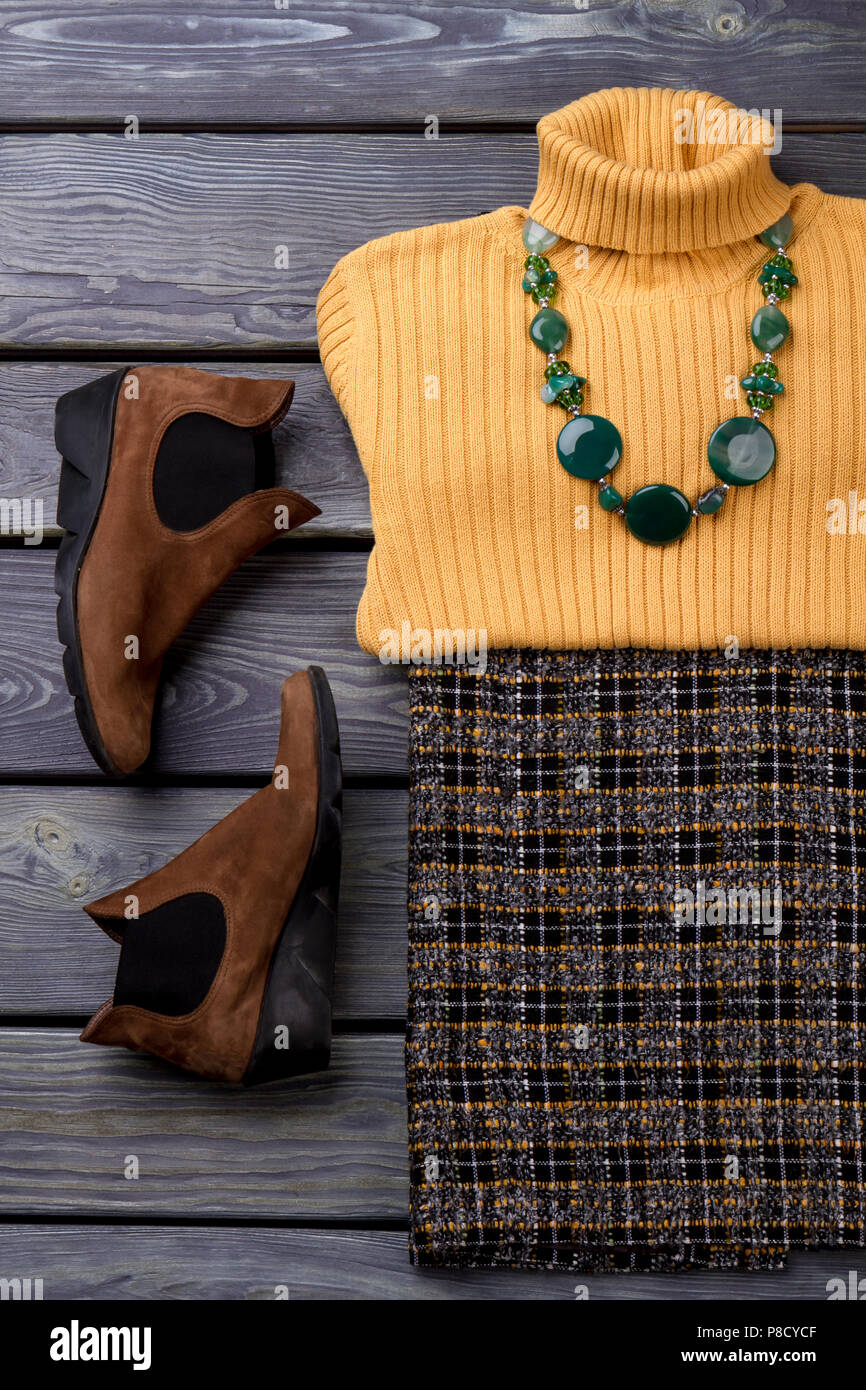 Folded yellow wool sweater with necklace Stock Photo - Alamy