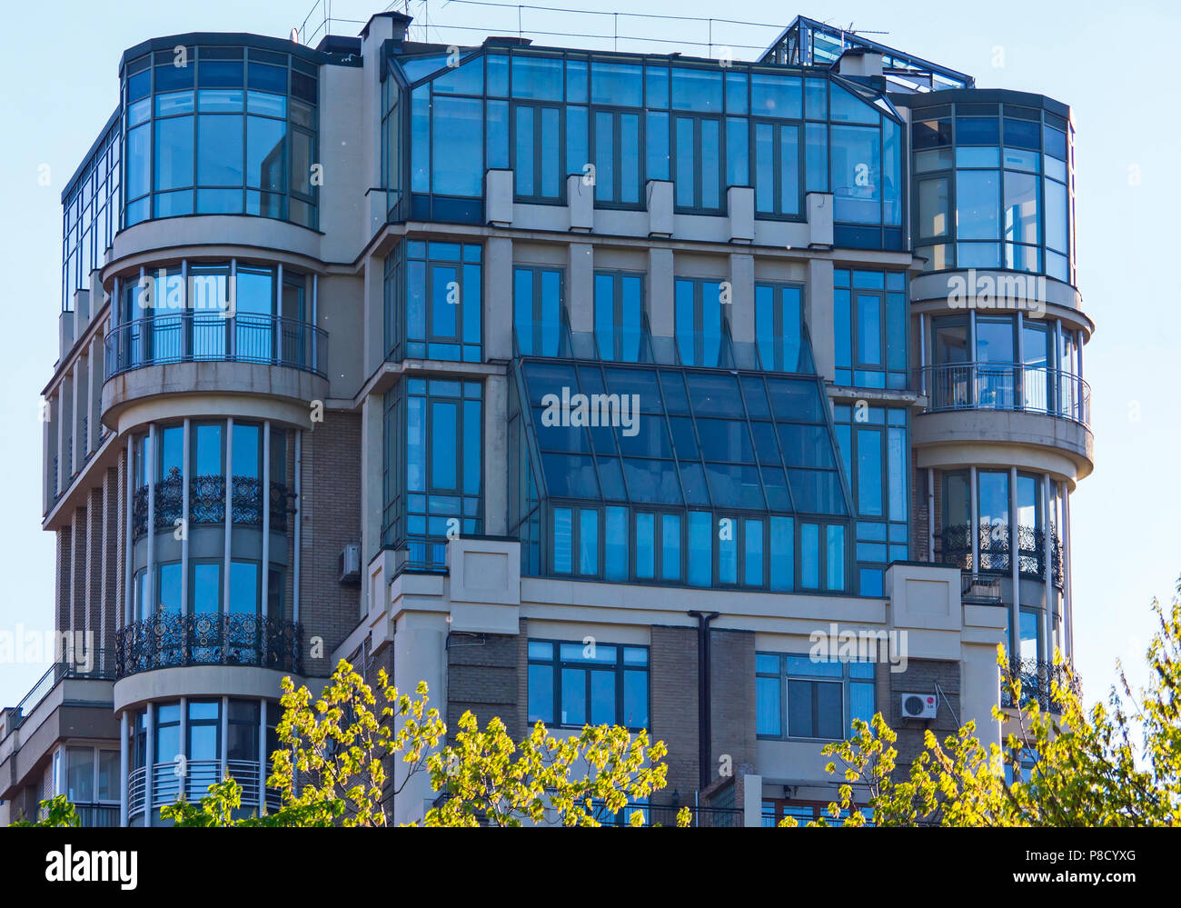 A tall modern building with large blue windows against the backdrop of ...