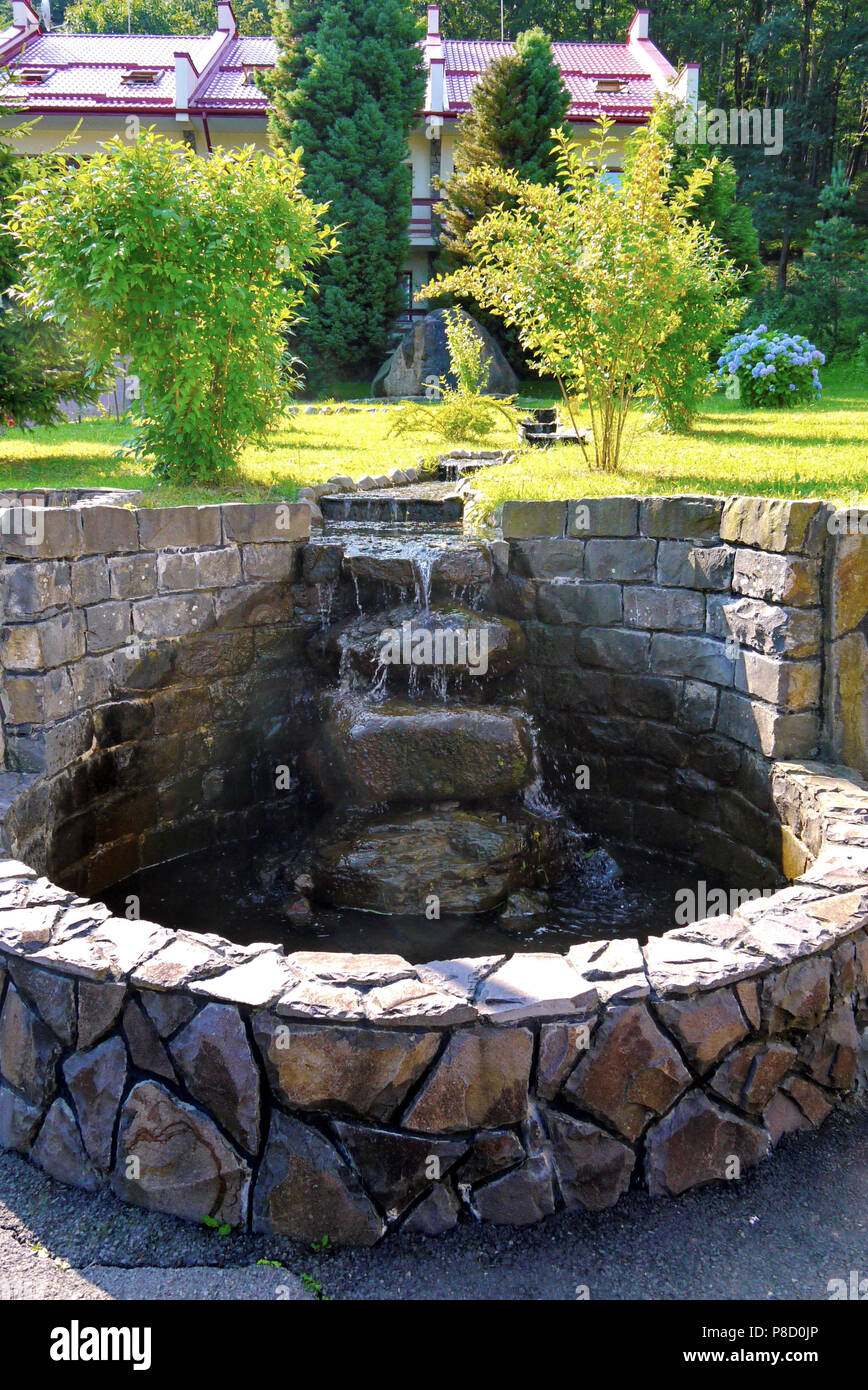 The spring is surrounded by a stone and turned into a fountain. The ...