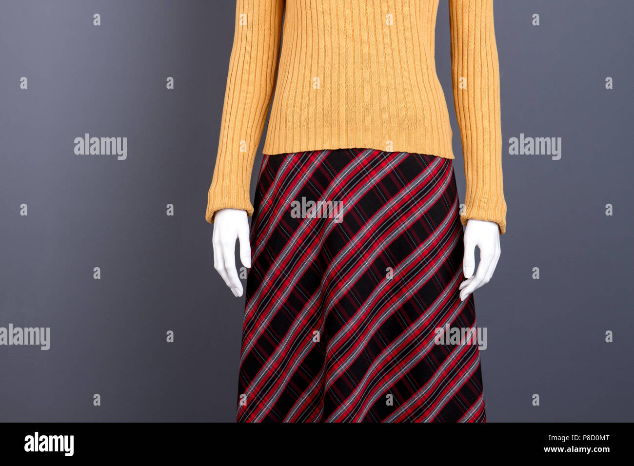 Yellow sweater and checkered skirt on mannequin, front view Stock Photo ...
