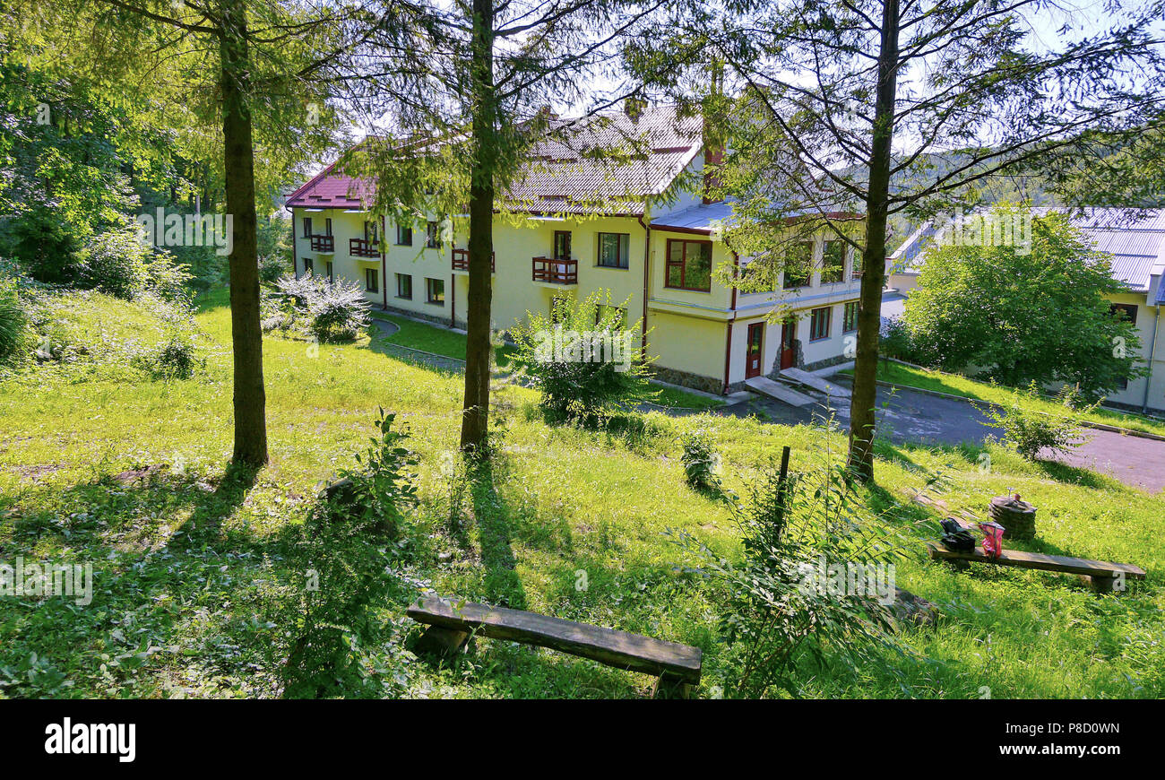 wooden benches for rest standing in the shade of trees on the hillside ...