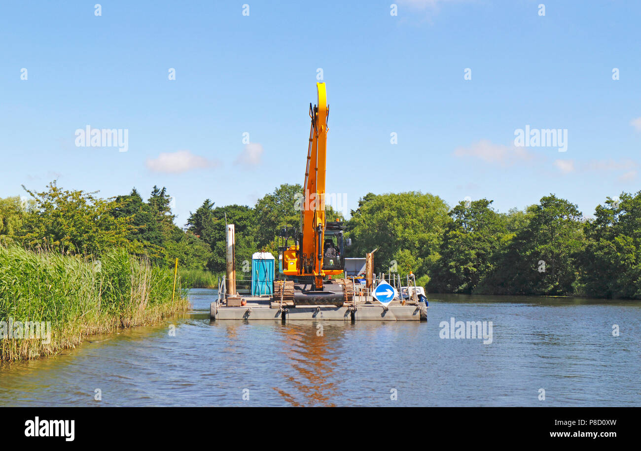 A pontoon with dredging equipment aboard on the River Bure on the ...