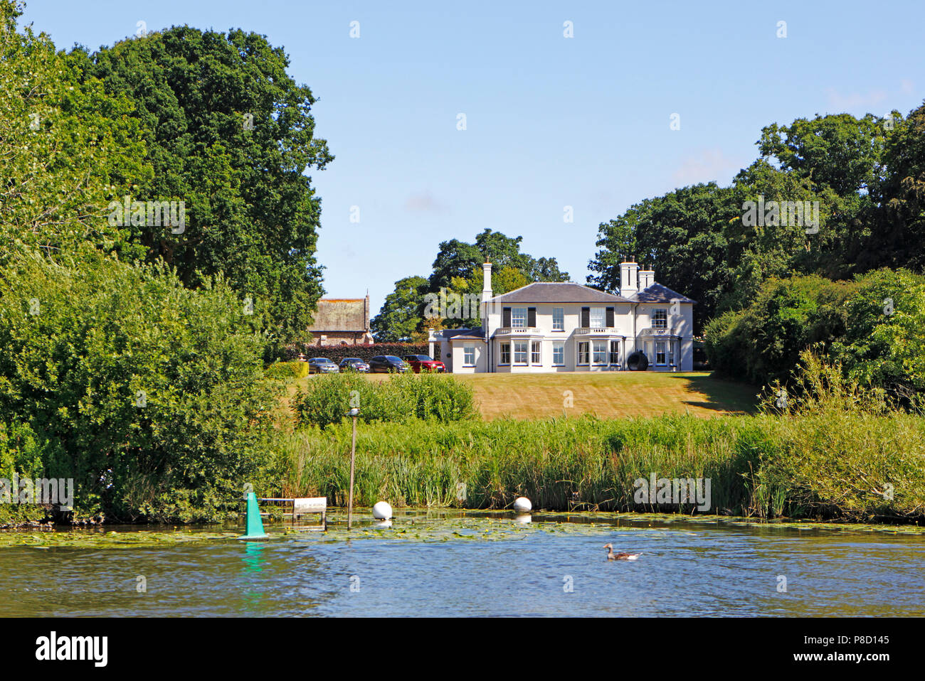 A view of the Old Vicarage from the River Bure on the Norfolk Broads at ...