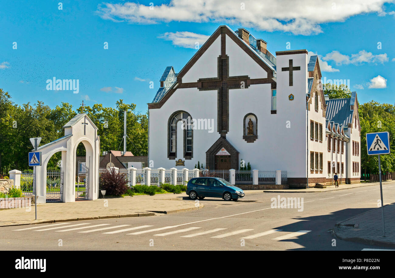 A large white church with interesting architectural windows and a gray ...