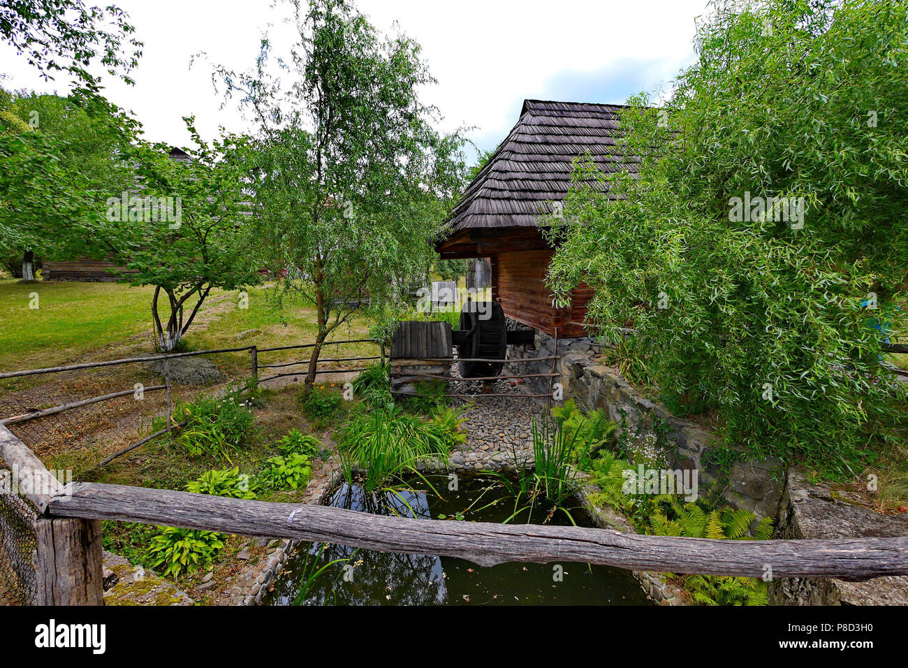A small well with a wheel under the roof of a wooden house . For your ...
