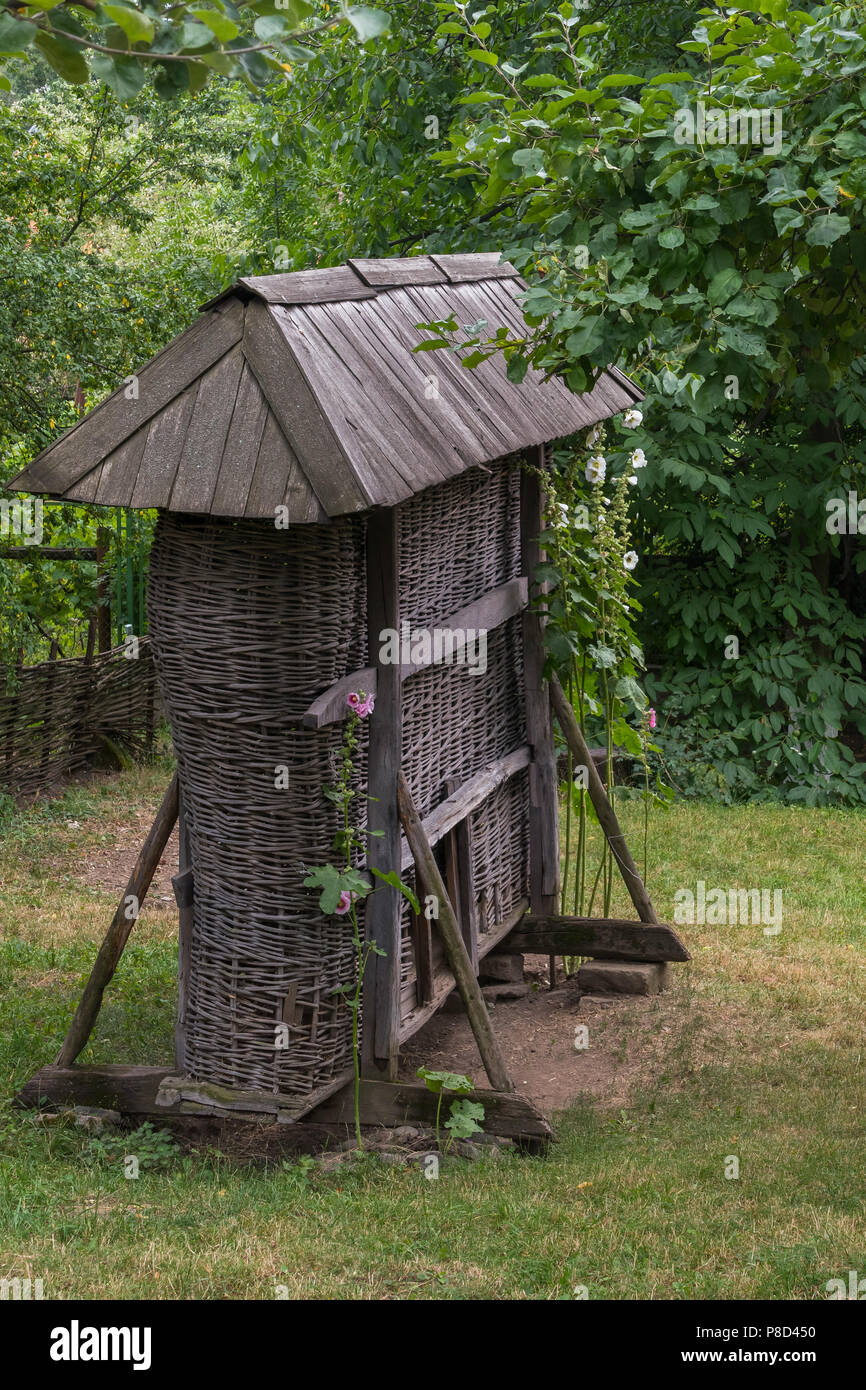 Decorative wooden well with a roof and curling flowers on the sides ...