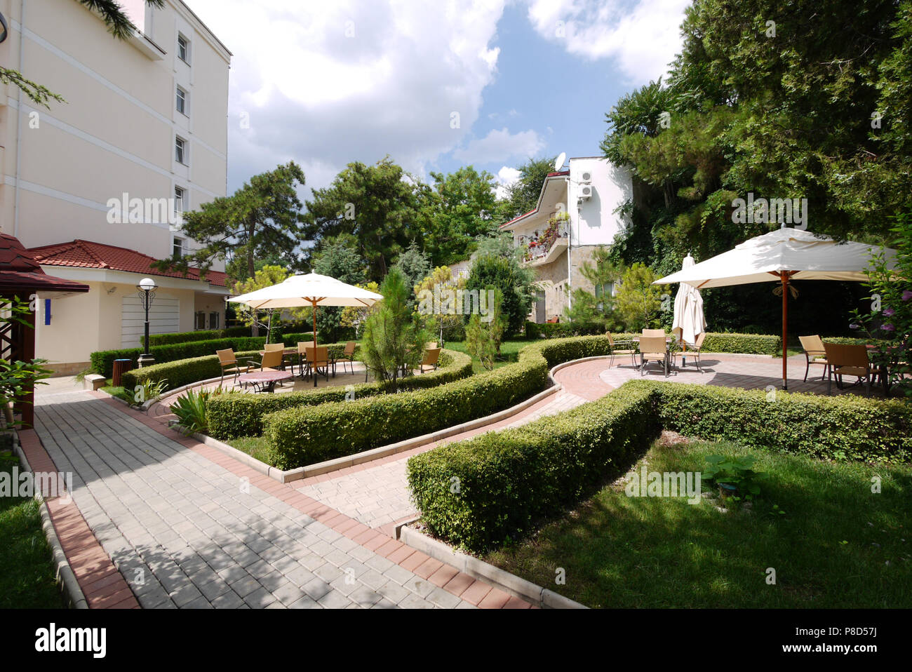Rest zone with comfortable chairs, tables and umbrellas against the ...