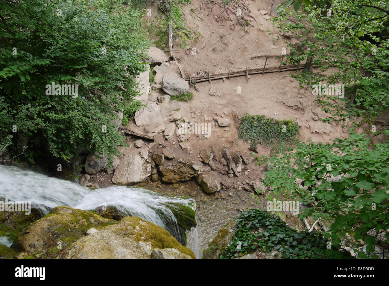 A top-down view of a waterfall flowing over rocks. Forming below a ...