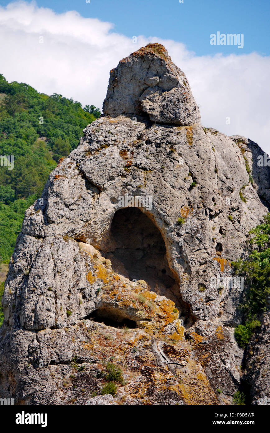 A gray rock with a red moss and a cave in it . For your design Stock ...