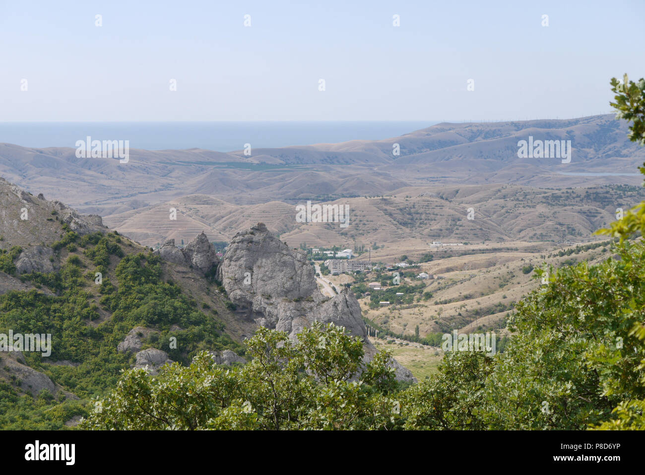The houses of a small village lying in a valley among the hills without ...