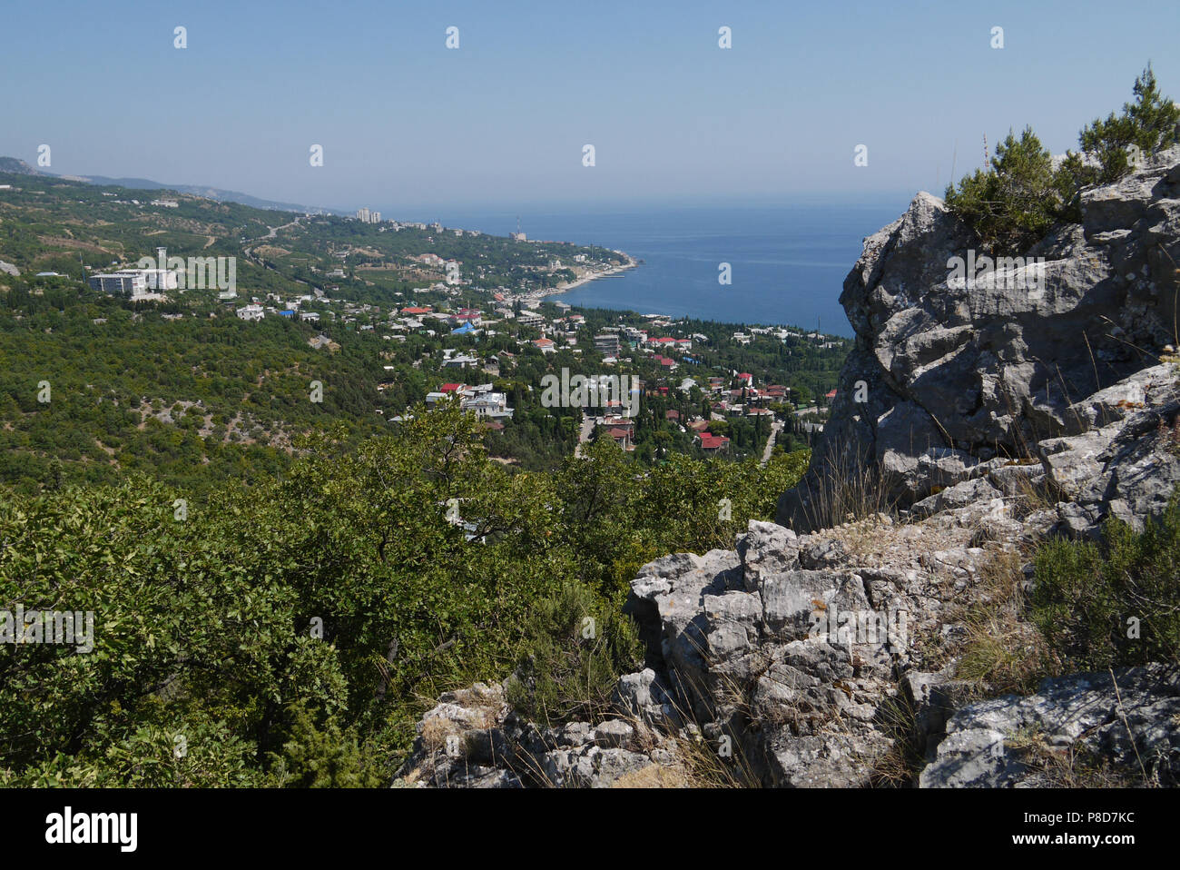 small grass-covered rocks on the background of a beautiful coastal town ...