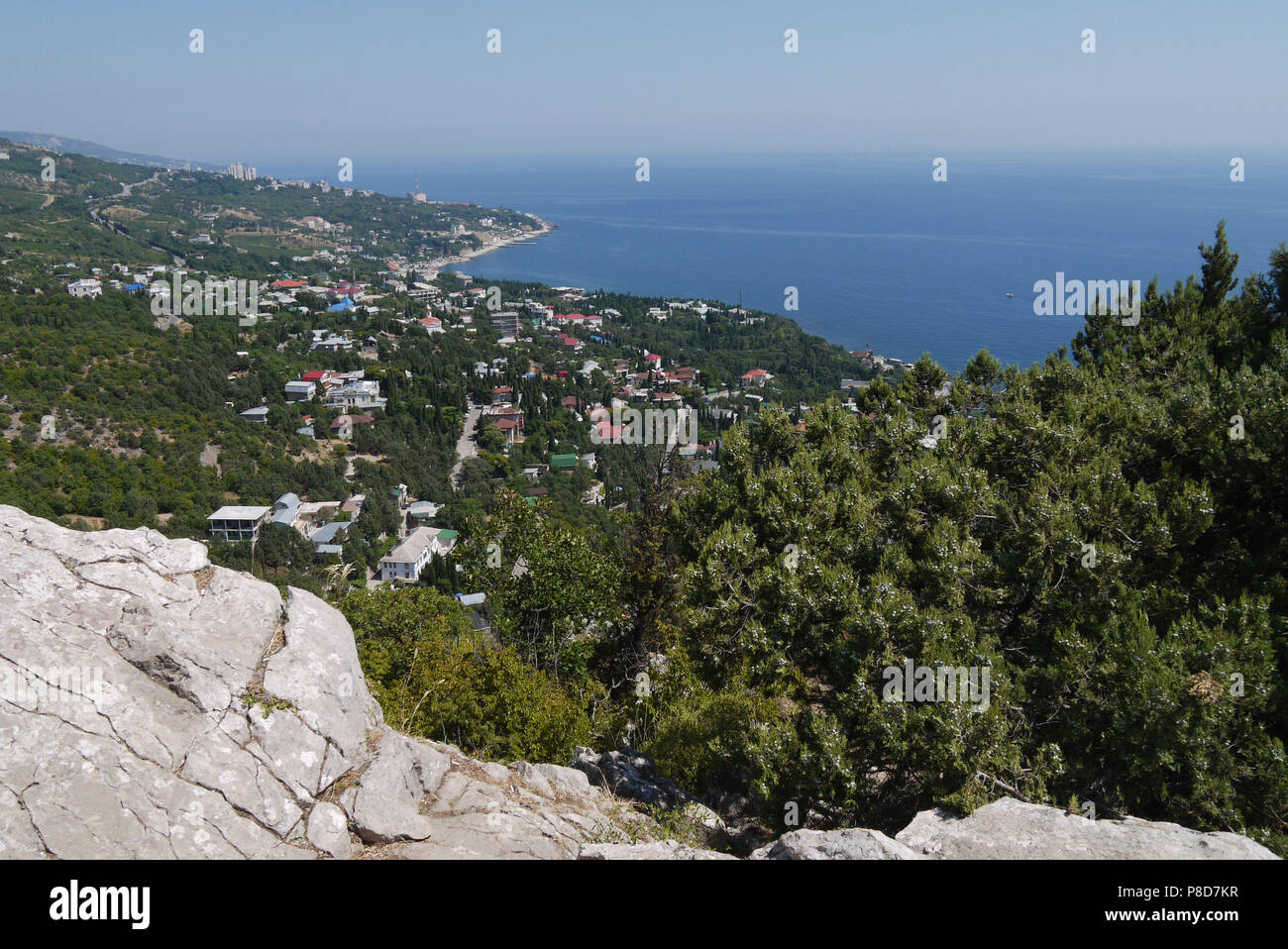 small grass-covered rocks on the background of a beautiful coastal town ...