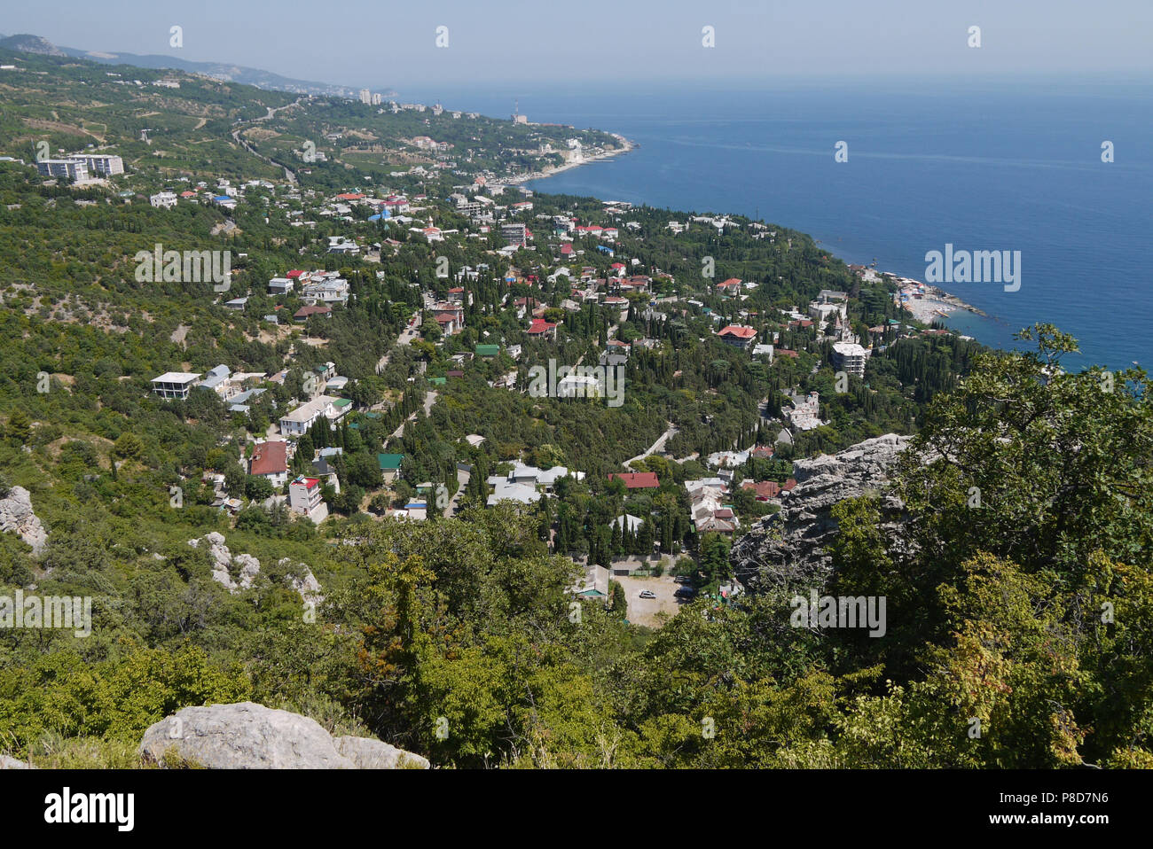 small grass-covered rocks on the background of a beautiful coastal town ...