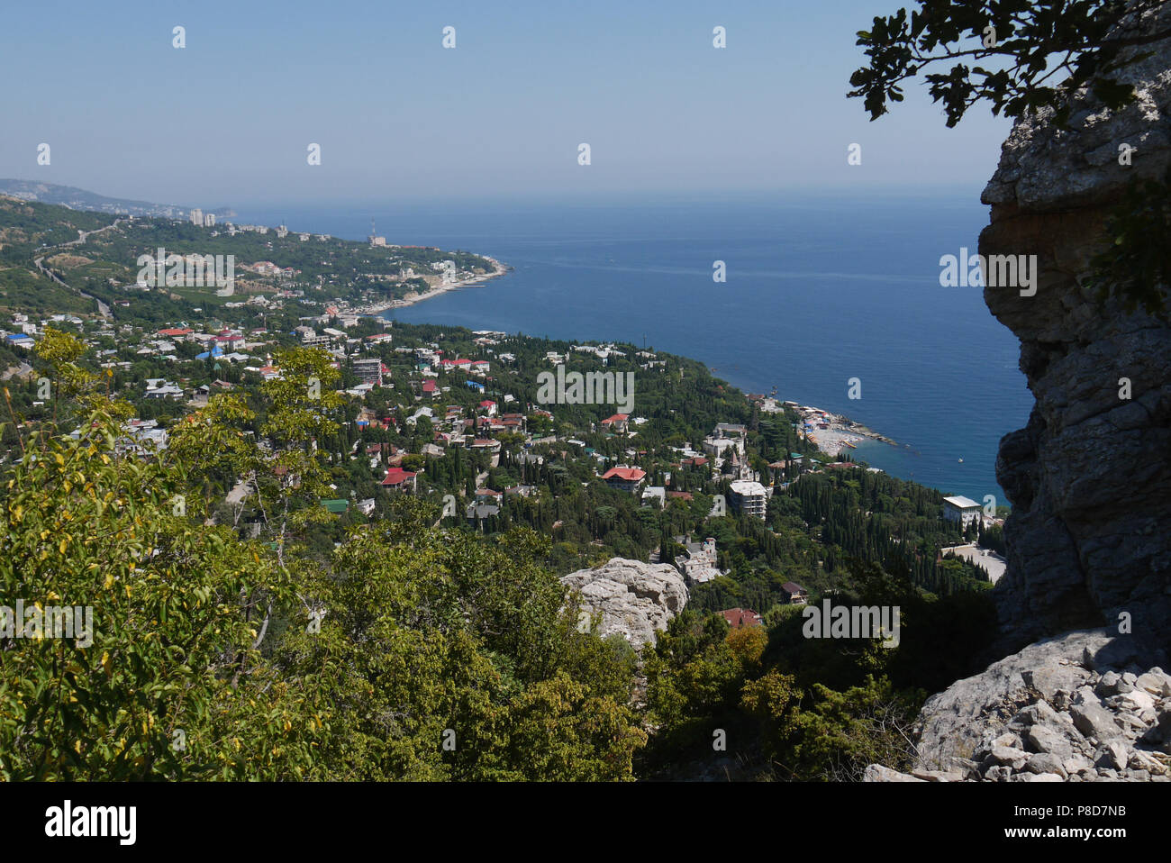 small grass-covered rocks on the background of a beautiful coastal town ...