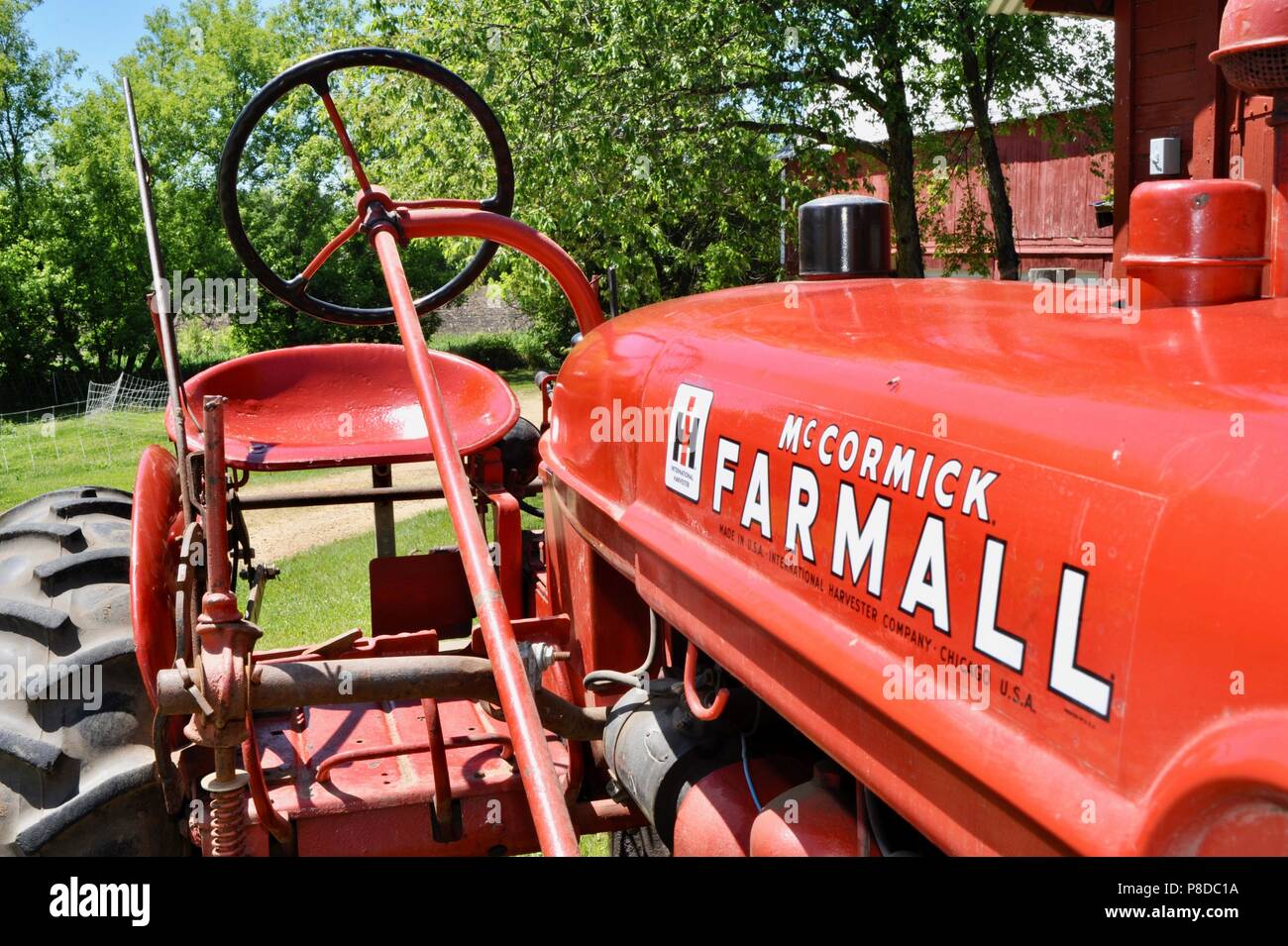 Well maintained, red McCormick Farmall farm tractor parked on farmstead ...