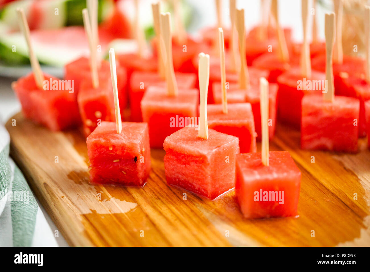 Preparing watermelon appetizers dipped in chocolate and sprinked with ...