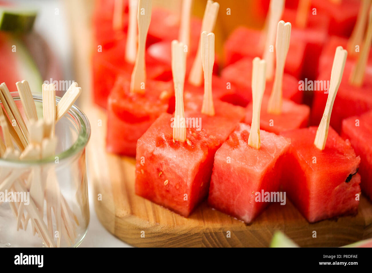 Preparing watermelon appetizers dipped in chocolate and sprinked with ...