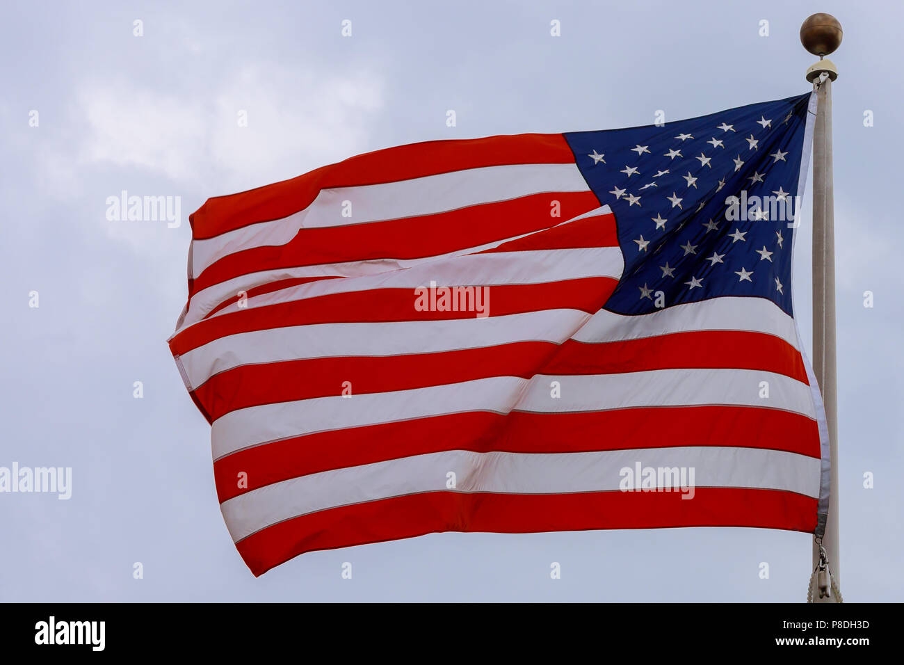 American flag flying, flag USA over blue sky background Stock Photo - Alamy