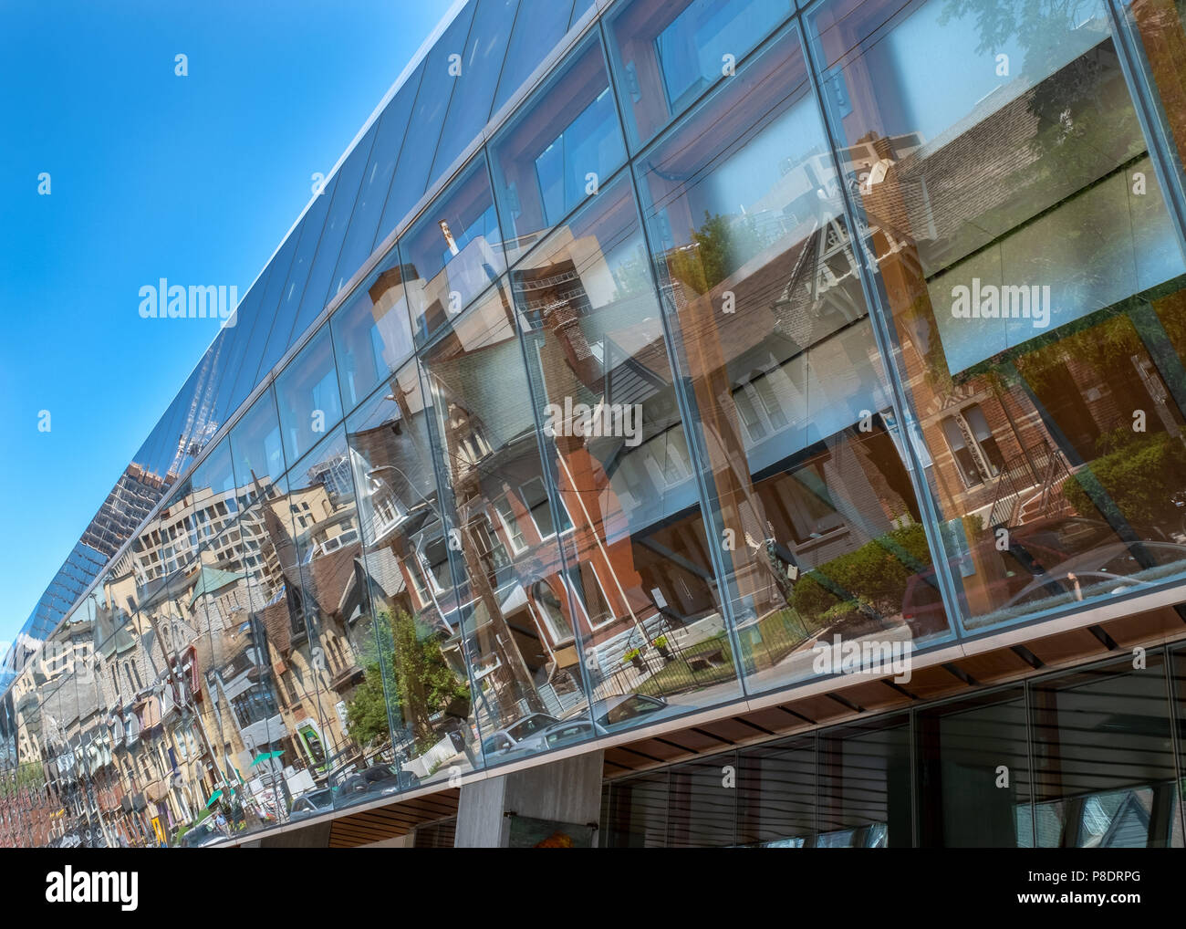 In a large modern city, a curved glass structure reflects the old ...