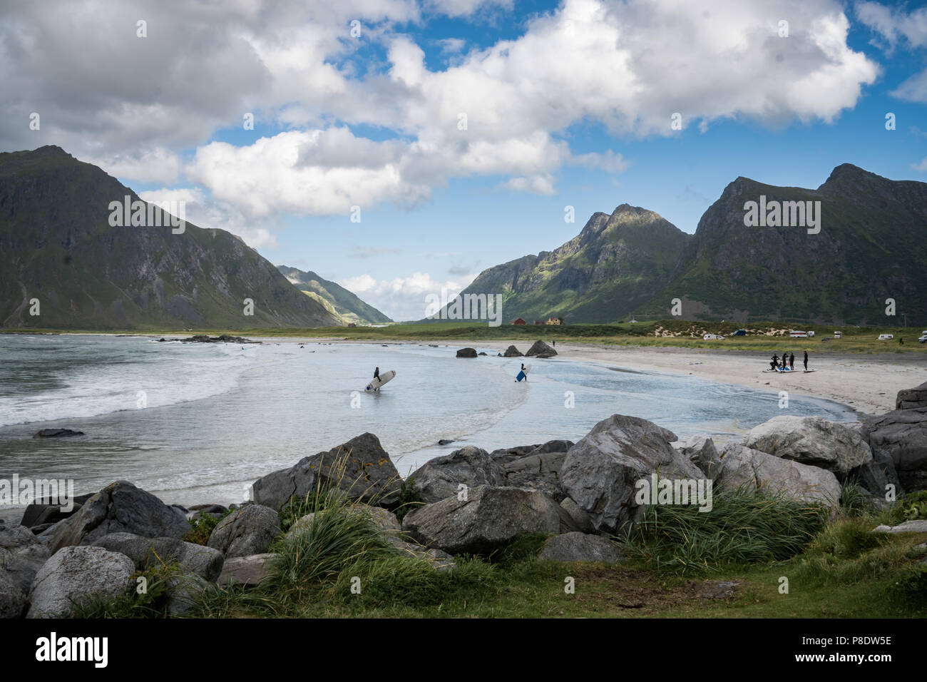 Landscape and surfers in arctic circle Norway with mountains and blue ...