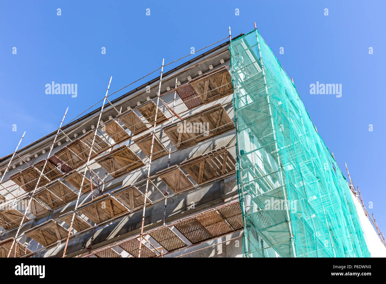 high scaffolding for building facade renovation against blue sky Stock ...
