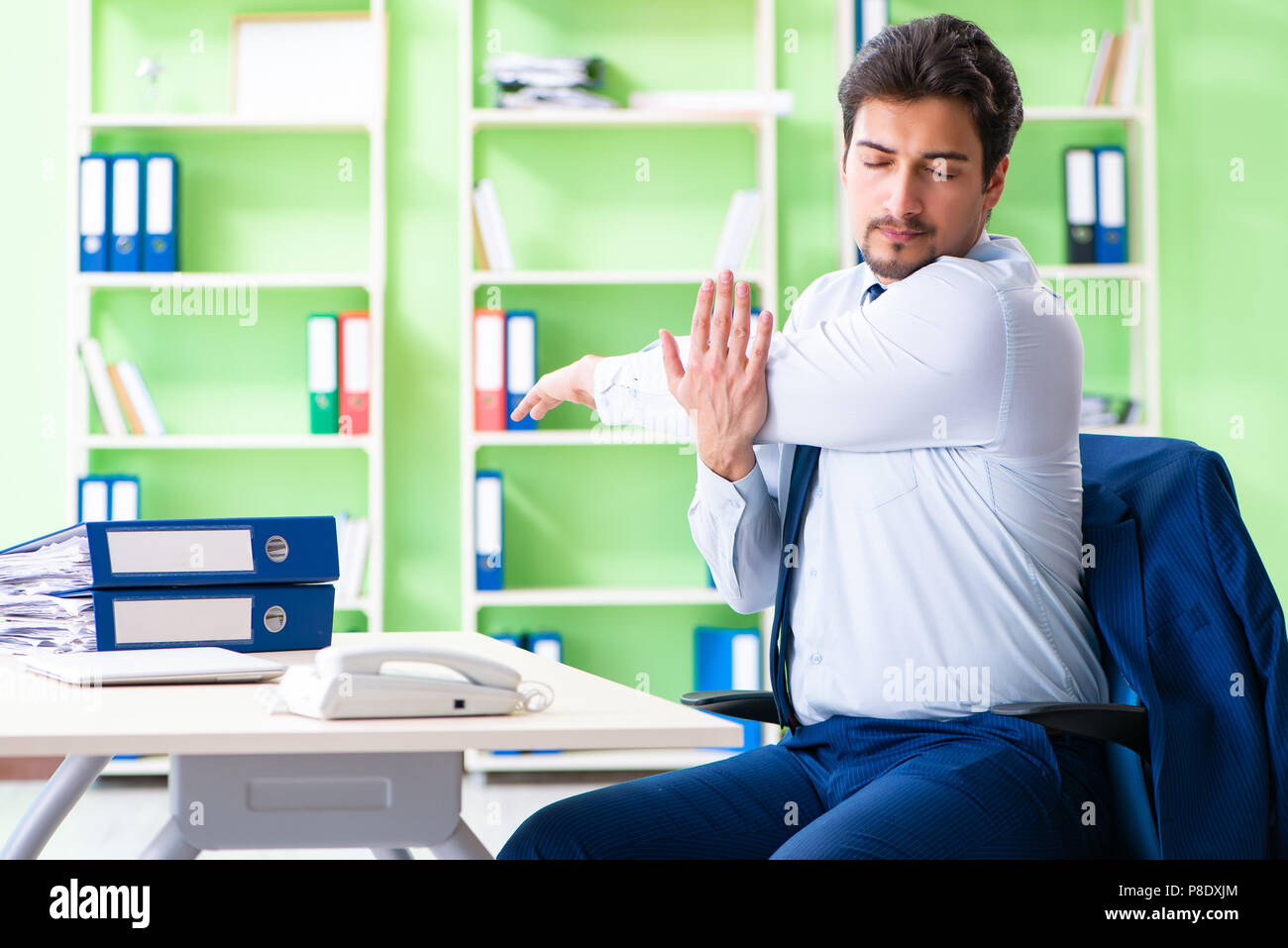 Employee doing exercises during break at work Stock Photo - Alamy