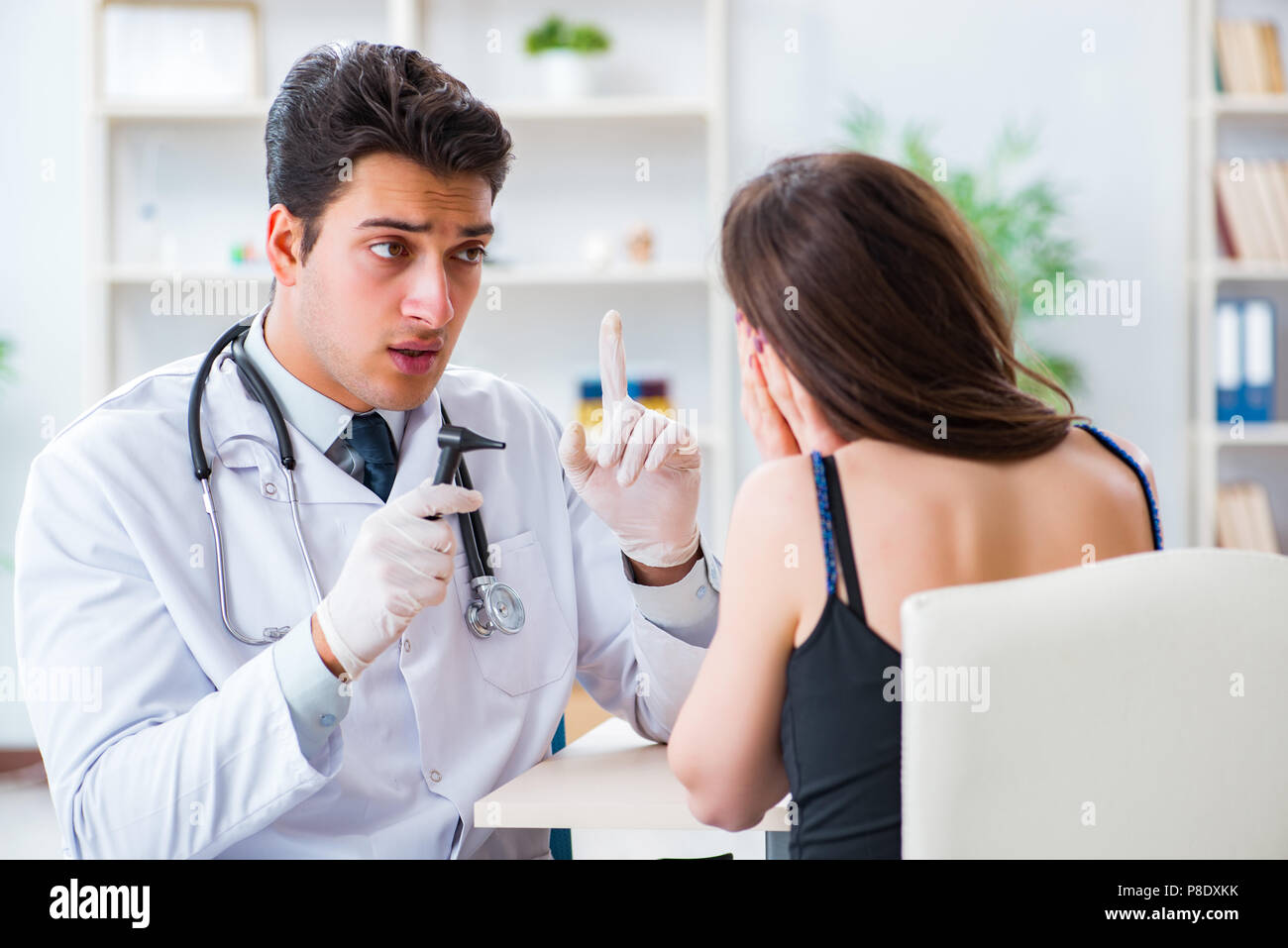 Doctor checking patients ear during medical examination Stock Photo - Alamy