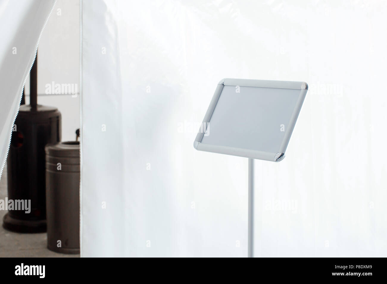 Metal sign holder stand at white wall Stock Photo - Alamy