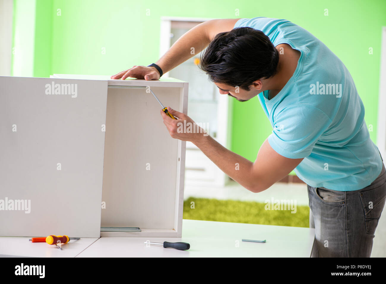 Man repairing furniture at home Stock Photo - Alamy