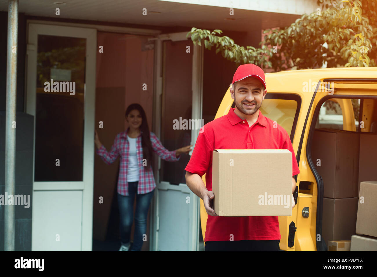 Delivery guy holding package Stock Photo - Alamy