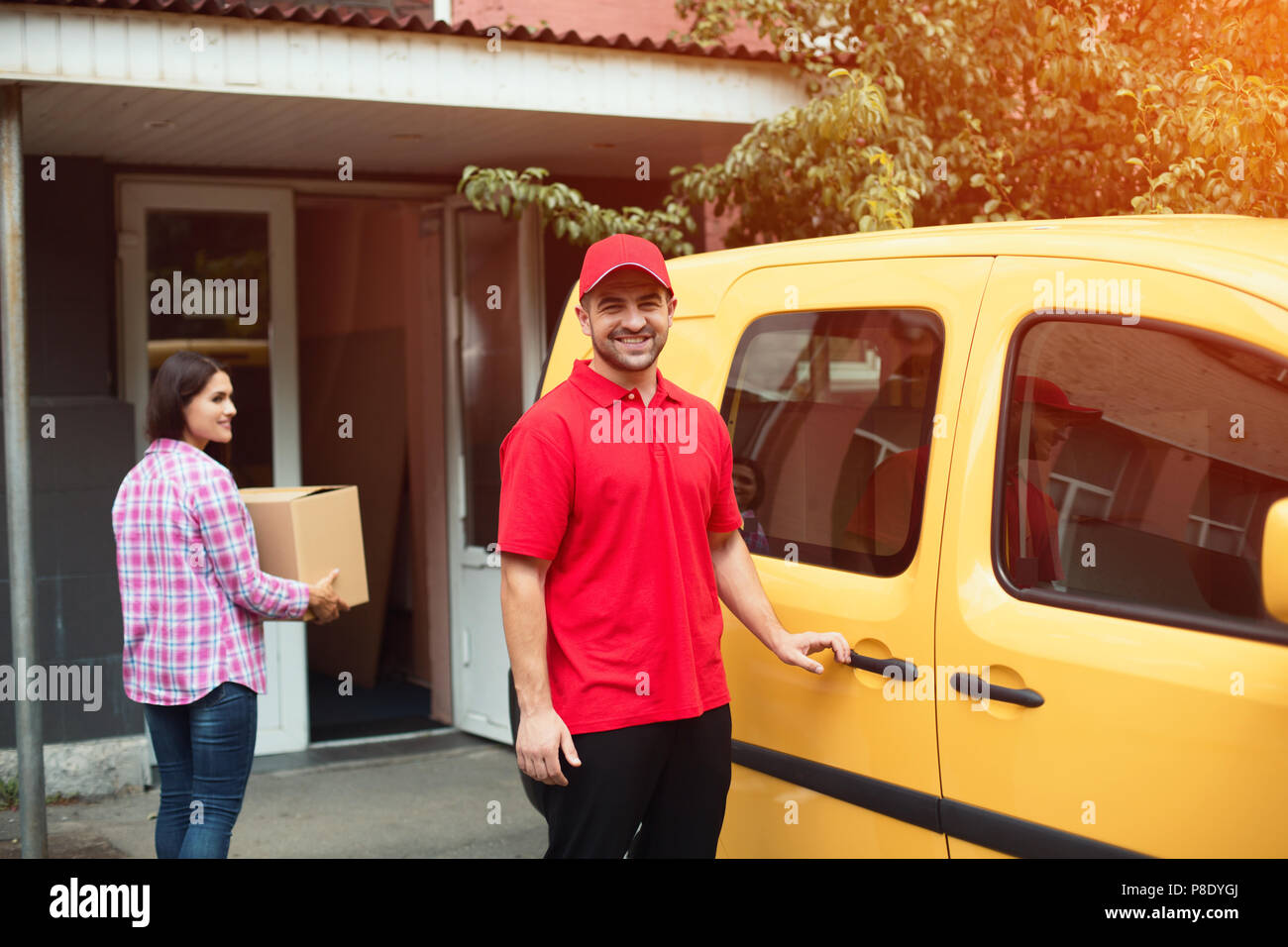 Delivery man handing package box Stock Photo - Alamy