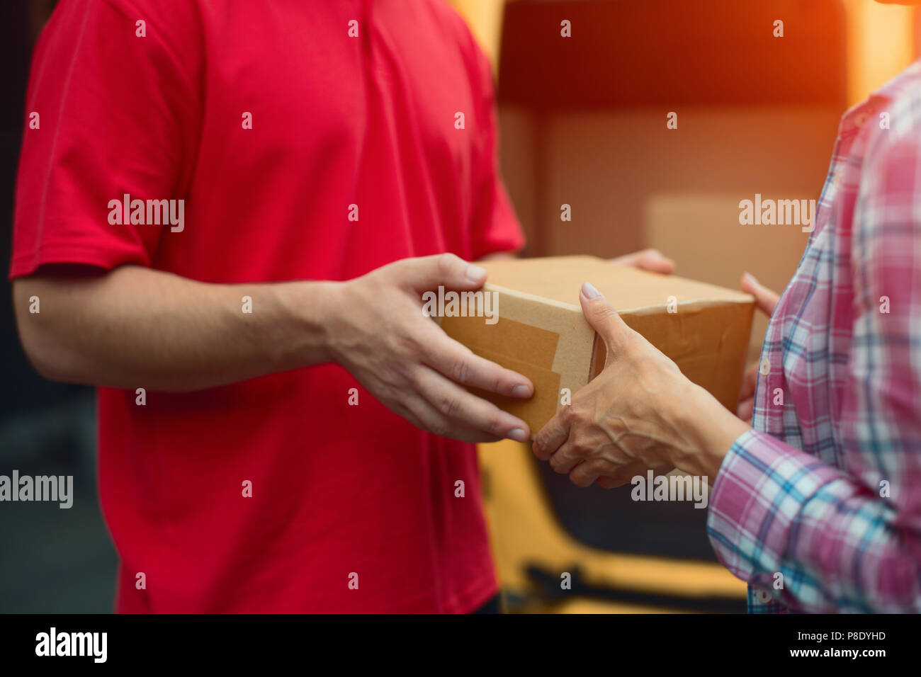 Delivery man handing package box Stock Photo - Alamy