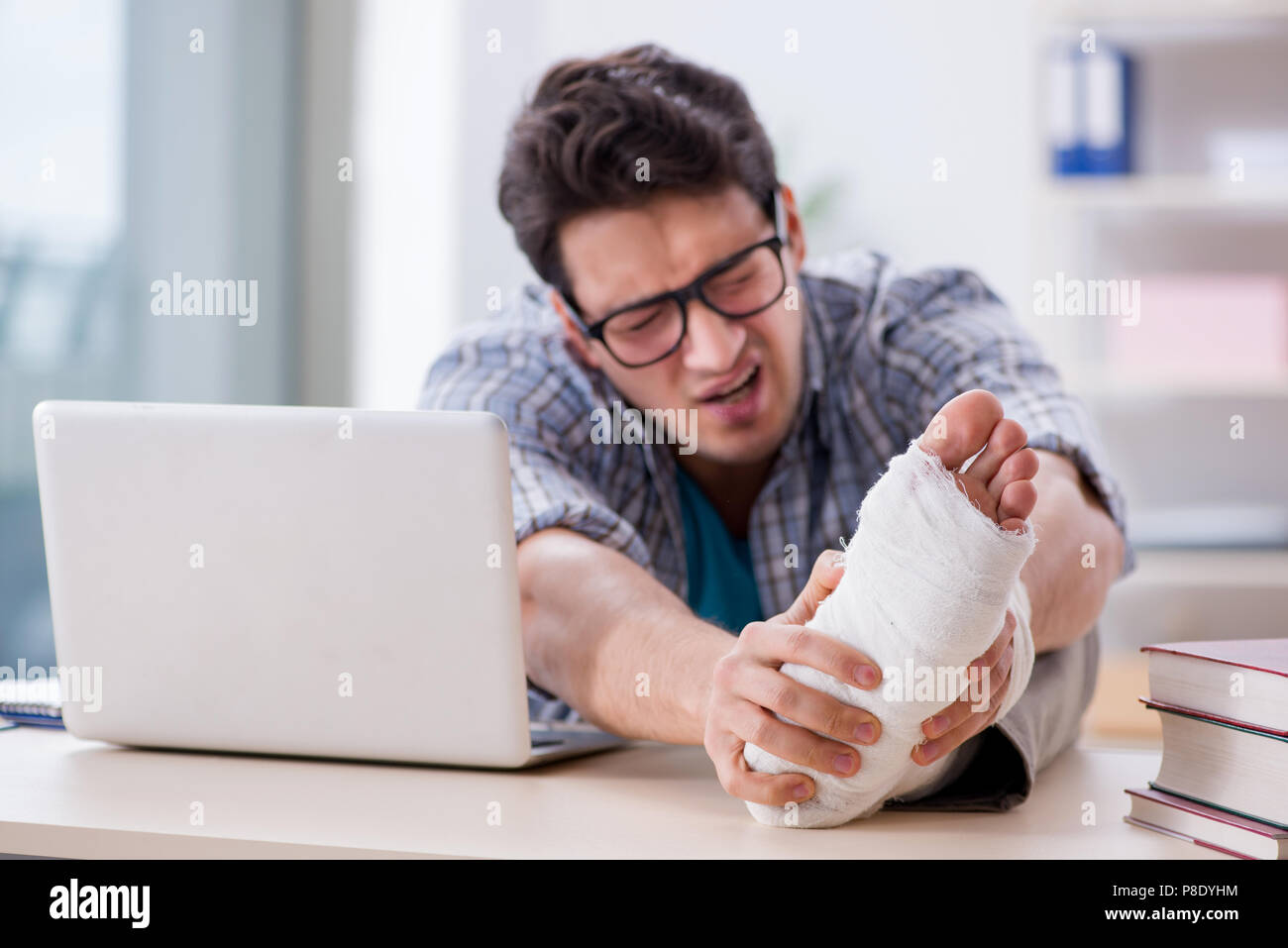 Freelancer with foot injury working from home Stock Photo - Alamy