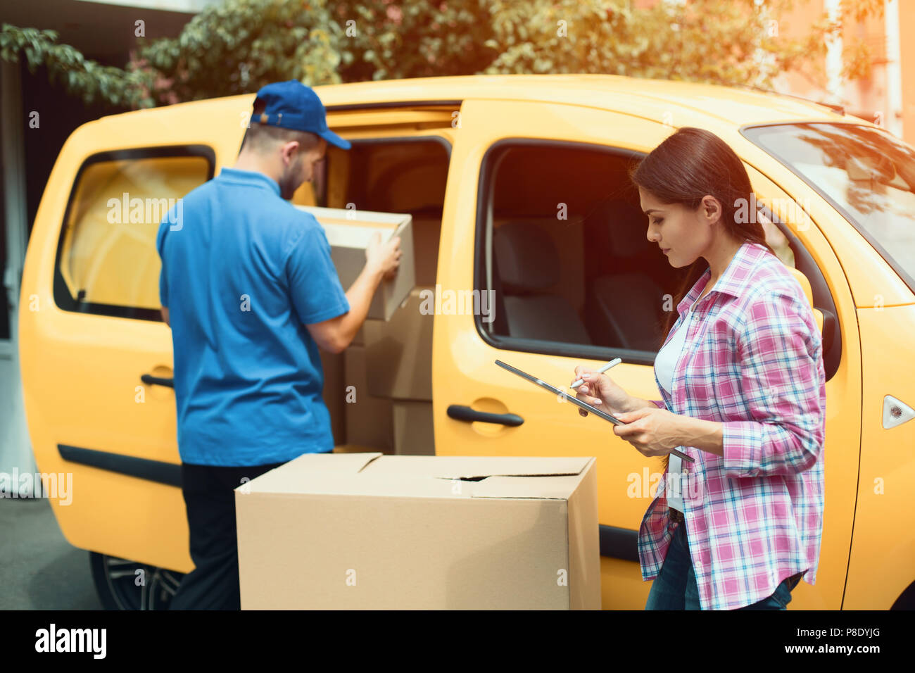 Woman signing delivery Stock Photo - Alamy