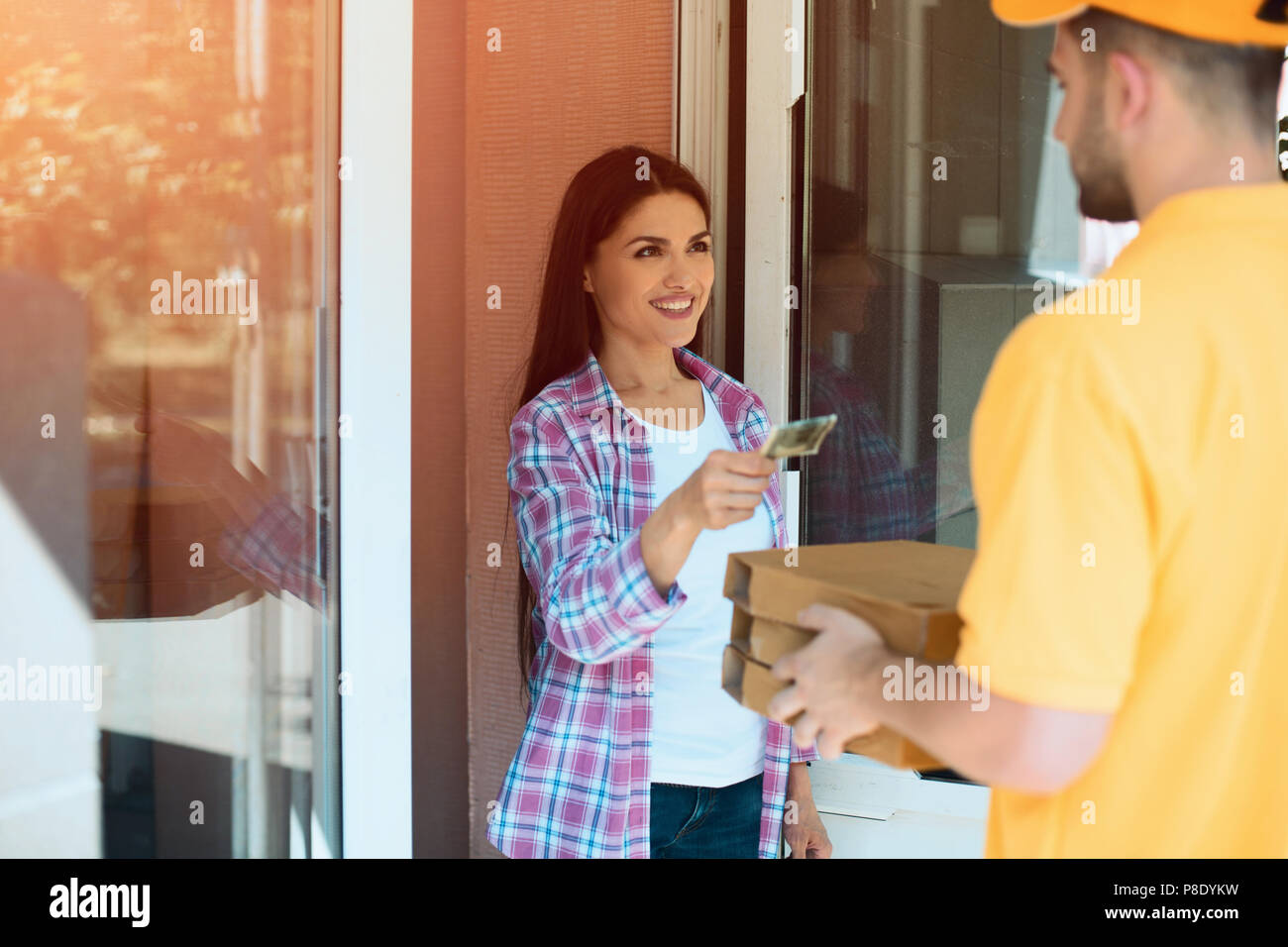 Delivery man handing pizza boxes Stock Photo - Alamy