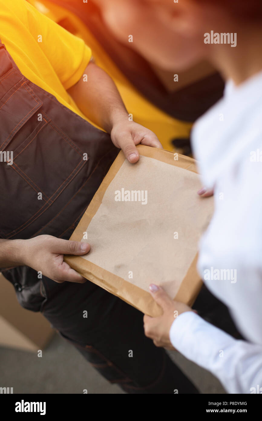 Delivery man handing envelope Stock Photo - Alamy