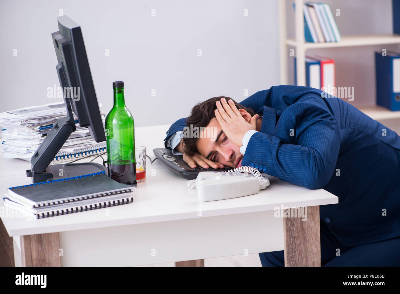 Young businessman employee drinking in the office at desk Stock Photo ...