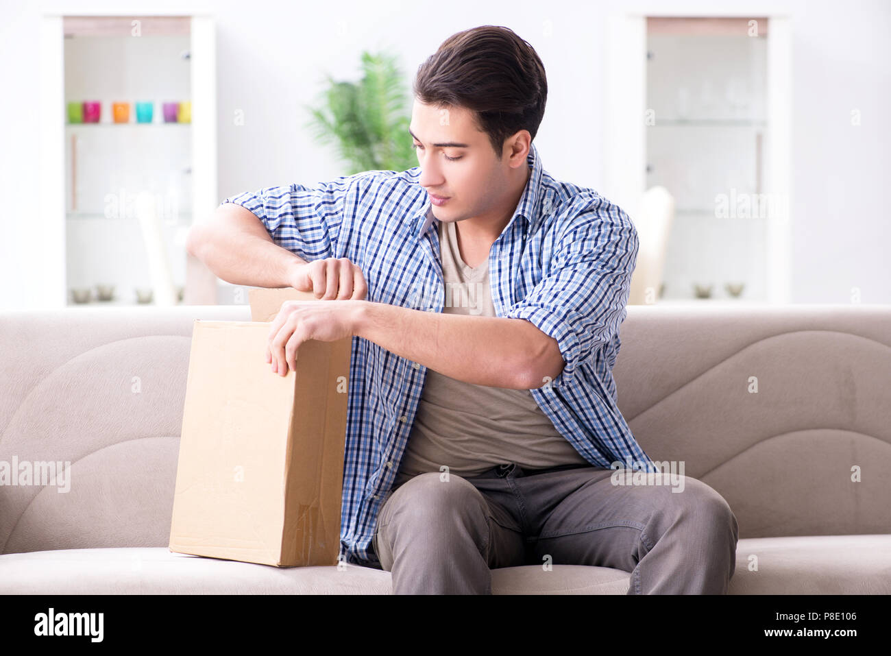 Man receiving parcel at home Stock Photo - Alamy