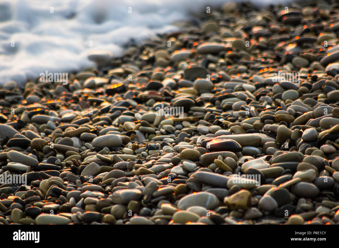 pebble stones on the sea beach on a warm summer day, the rolling waves ...
