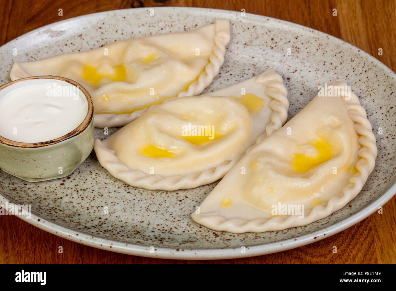 Ukrainian dumplings - vareniki with cream sauce Stock Photo - Alamy