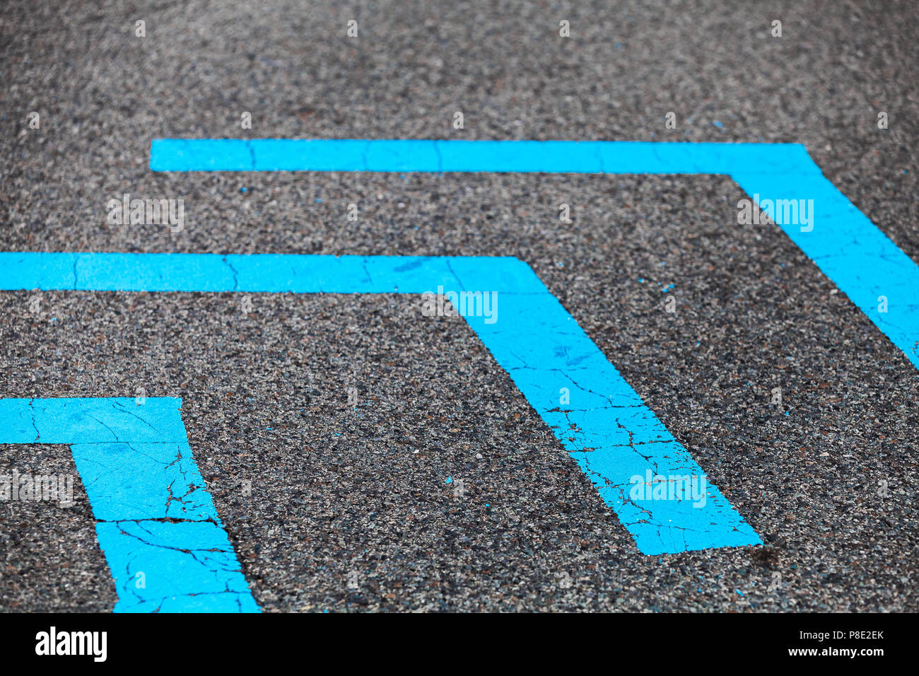 Corners of blue lines over dark asphalt, close-up photo with selective ...