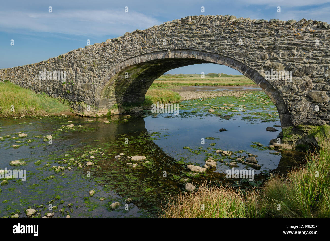 The old arched bridge which crosses the River next to the village of ...