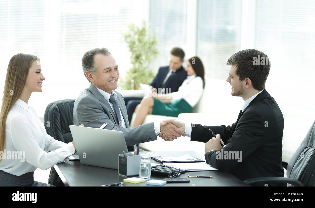handshake business people behind a Desk in the office Stock Photo - Alamy