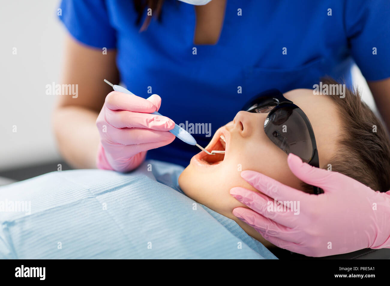 dentist checking for kid teeth at dental clinic Stock Photo - Alamy
