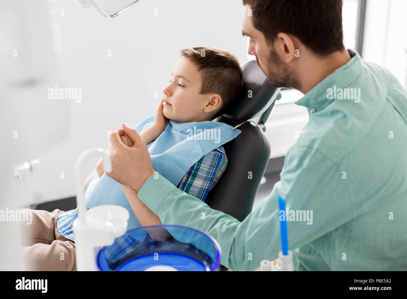 father supporting son at dental clinic Stock Photo - Alamy