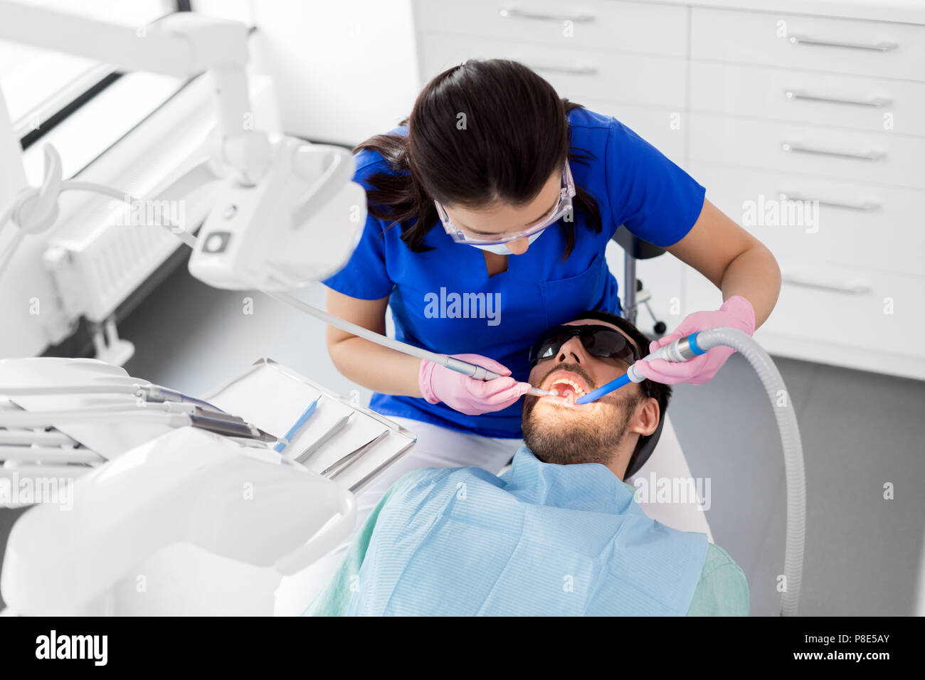 dentist treating patient teeth at dental clinic Stock Photo - Alamy