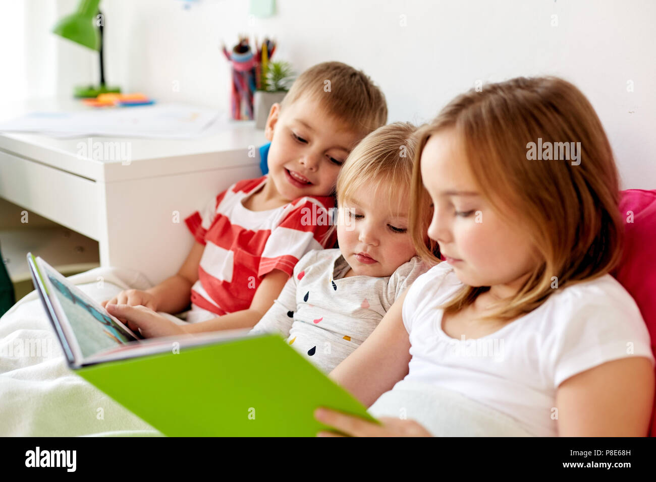 little kids reading book in bed at home Stock Photo - Alamy