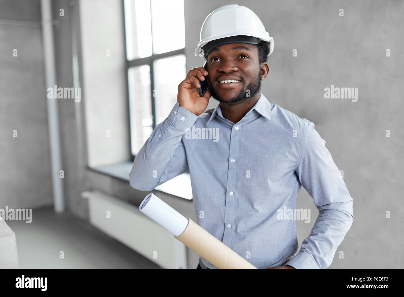 architect with blueprint calling on smartphone Stock Photo - Alamy